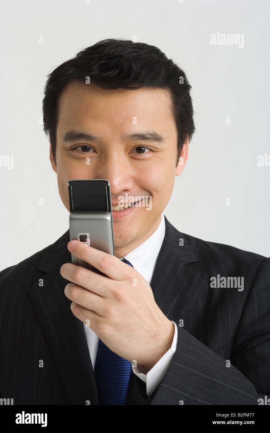 Portrait of a businessman text messaging and smiling Stock Photo - Alamy