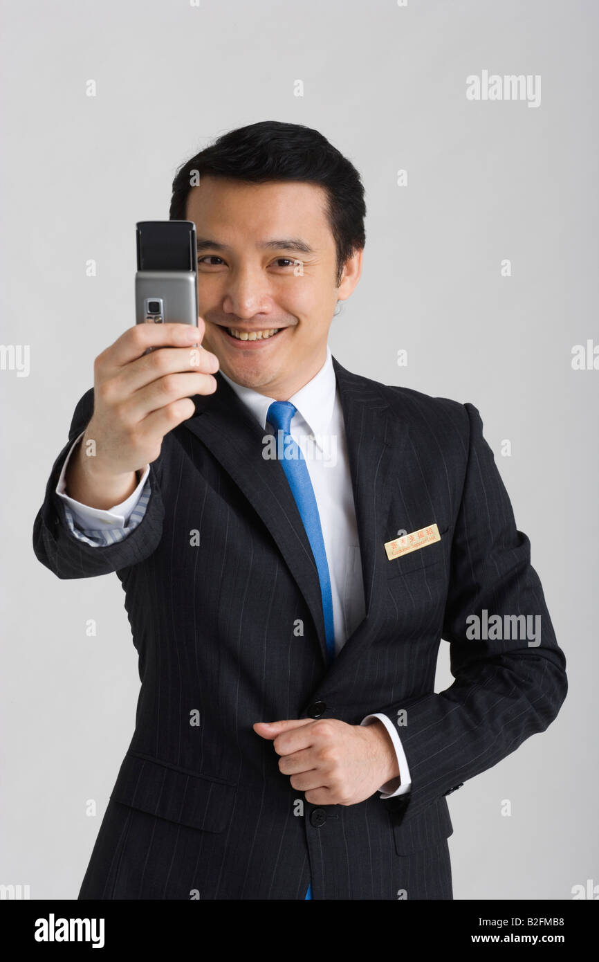 Portrait of a businessman text messaging and smiling Stock Photo - Alamy