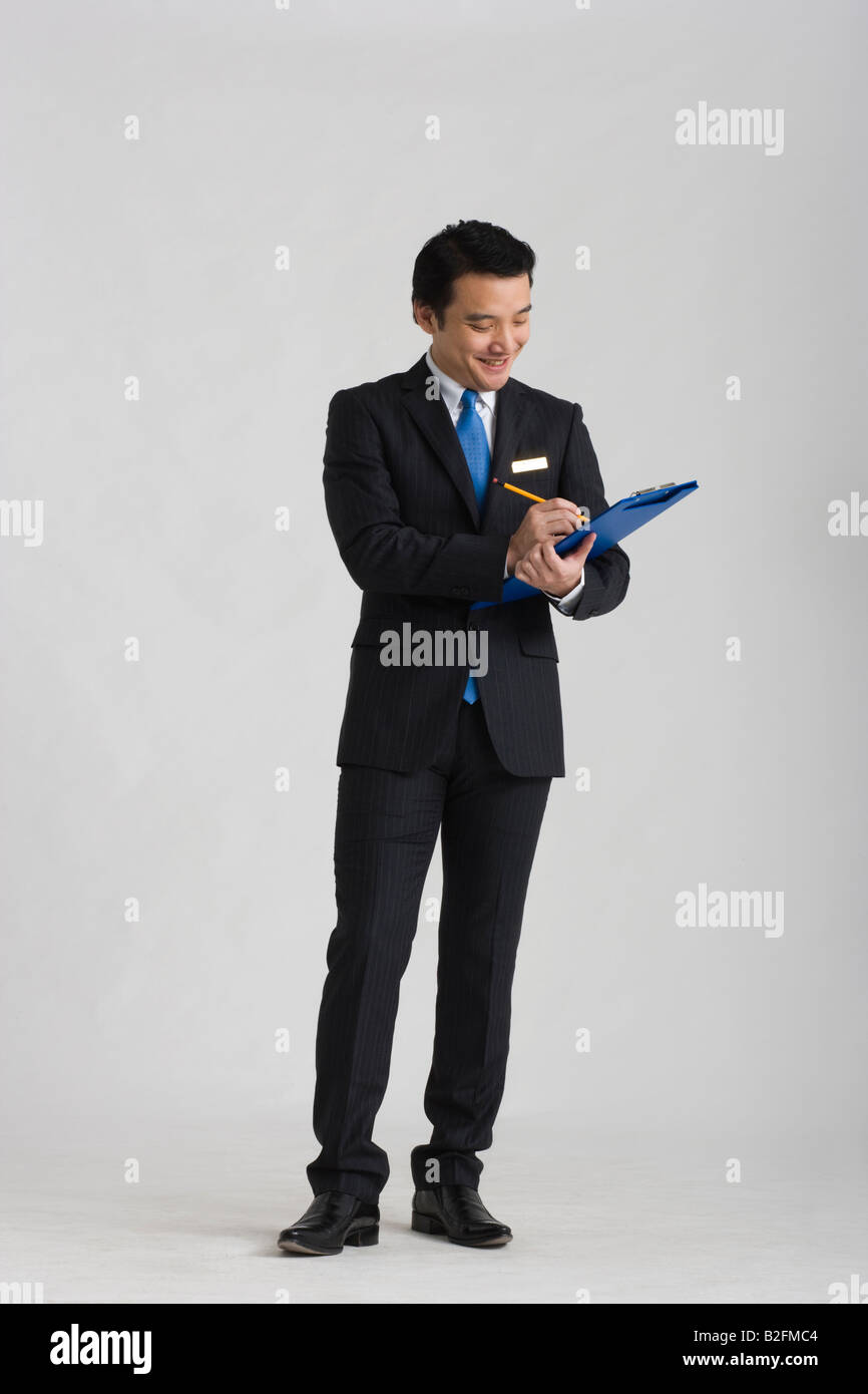 Businessman holding a clipboard and smiling Stock Photo - Alamy