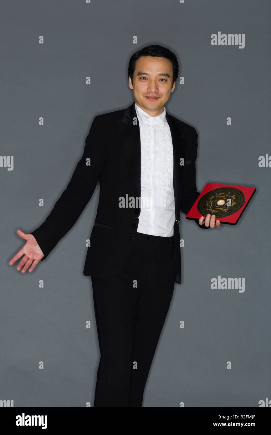 Portrait of a young man holding a Luo Pan and smiling Stock Photo - Alamy