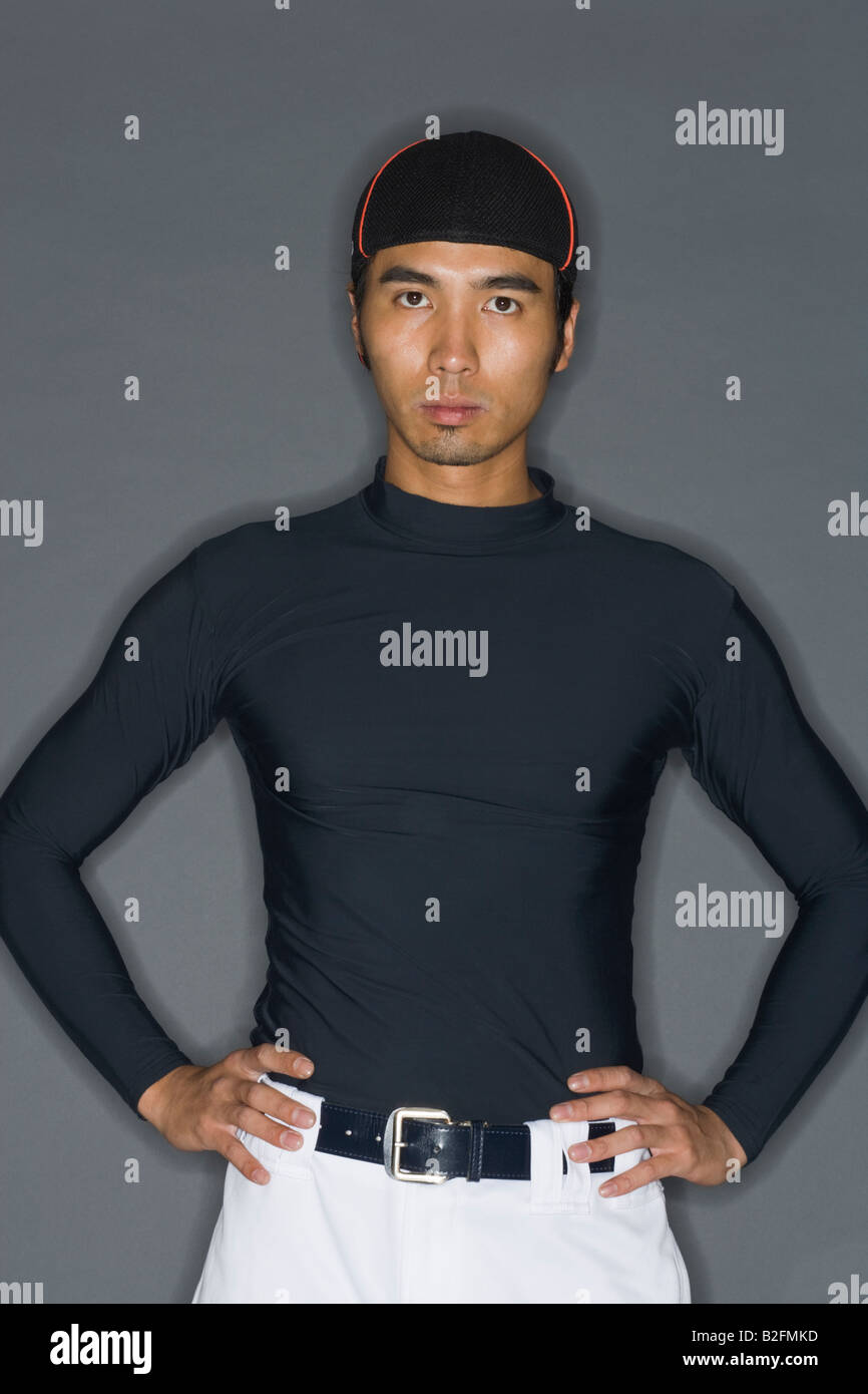 Portrait of a young man standing with arms akimbo Stock Photo - Alamy