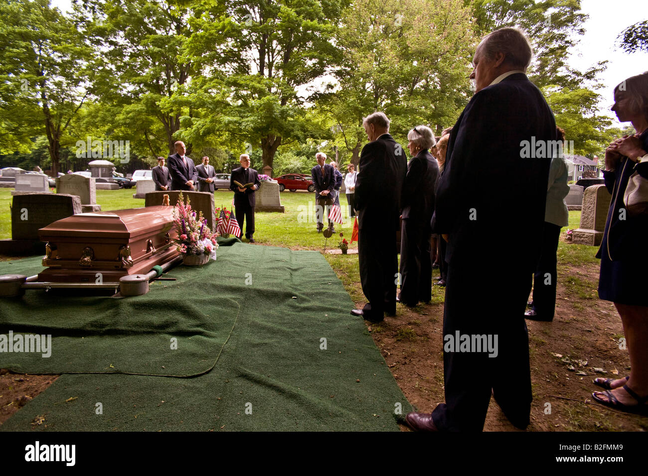 A priest officiates at a burial at a Catholic cemetary in Stoneham MA ...