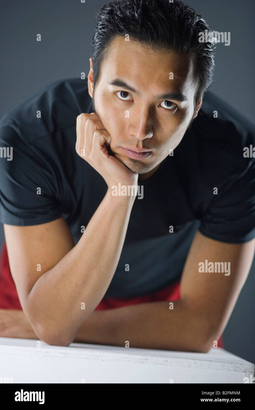 Portrait of a young man leaning on elbows Stock Photo - Alamy