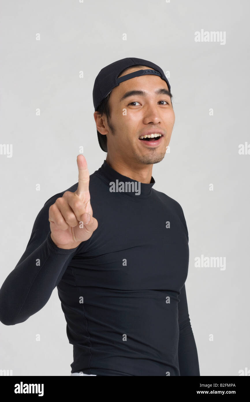 Portrait of a young man pointing and smiling Stock Photo - Alamy