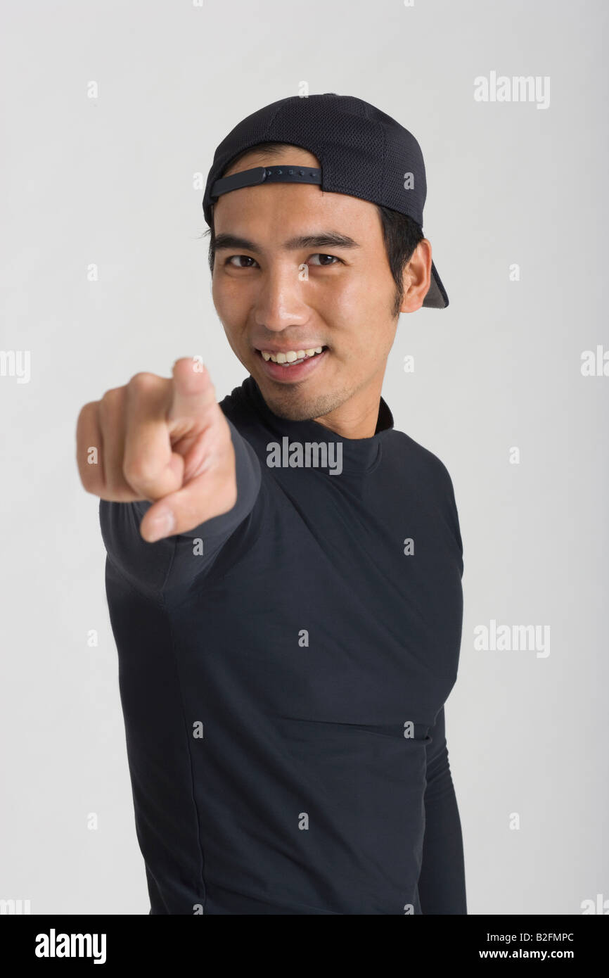 Portrait of a young man pointing and smiling Stock Photo - Alamy
