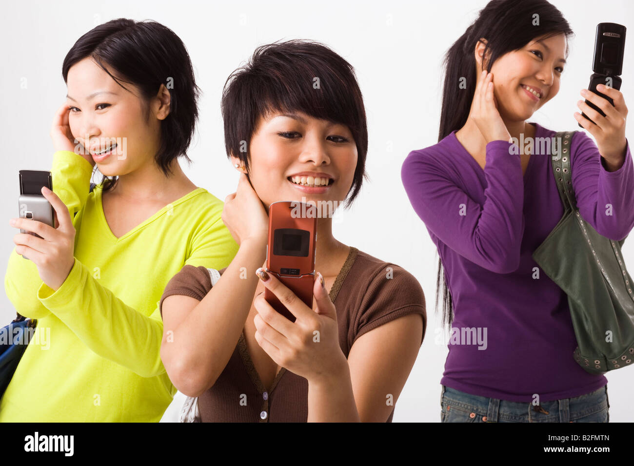 Three young women using mobile phones as mirrors Stock Photo - Alamy