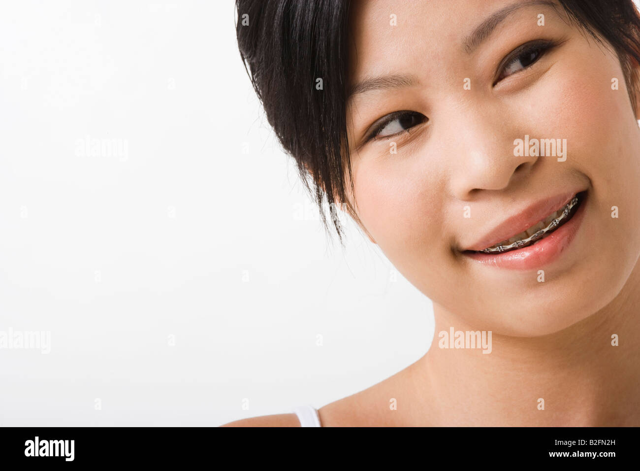 Close-up of a young woman thinking and smiling Stock Photo - Alamy