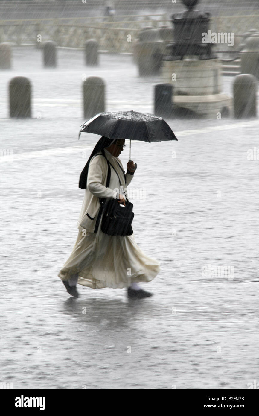 one nun in heavy rain in st peters square rome Stock Photo - Alamy