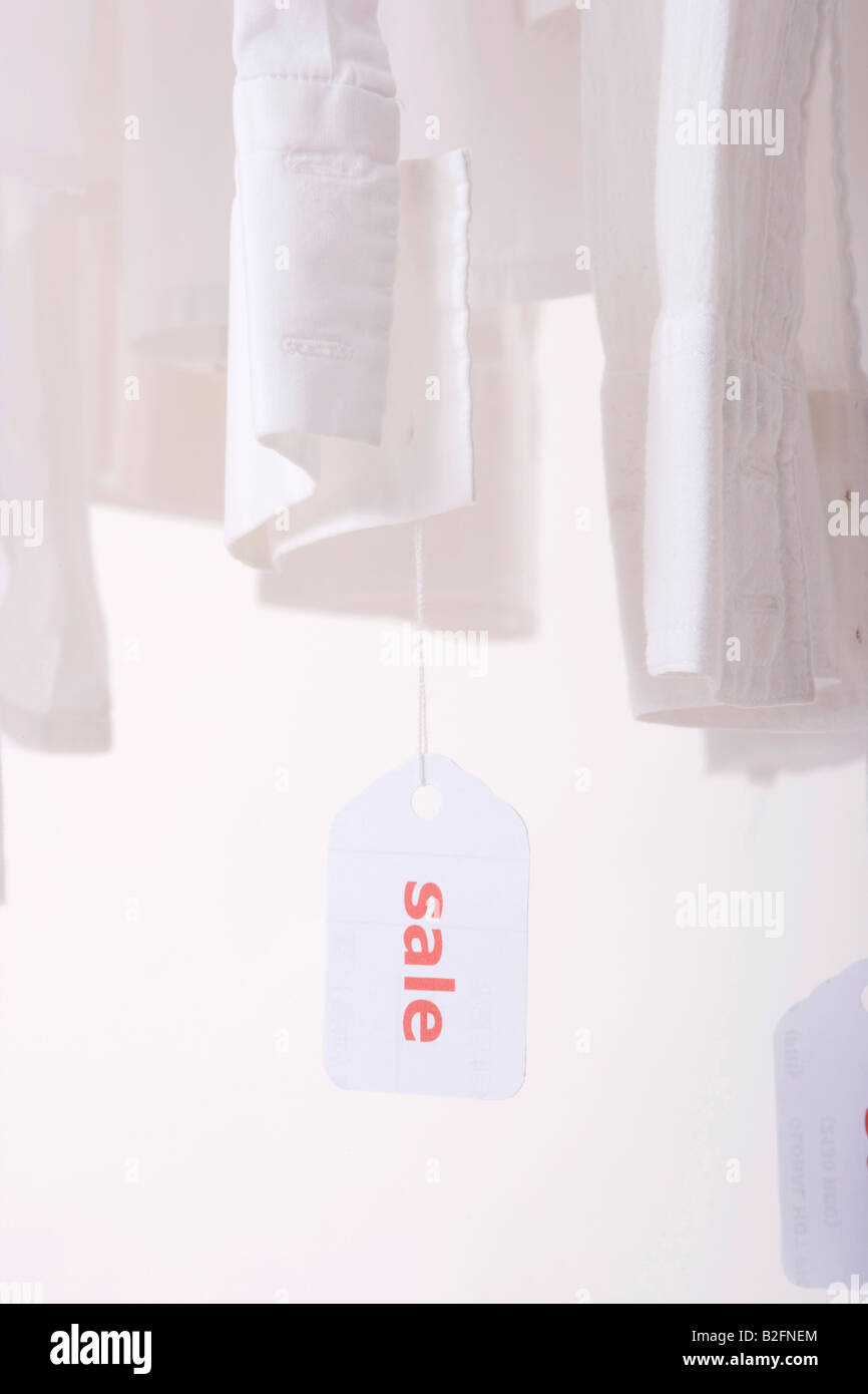 Shirts with a sale tag hanging in a clothing store Stock Photo - Alamy