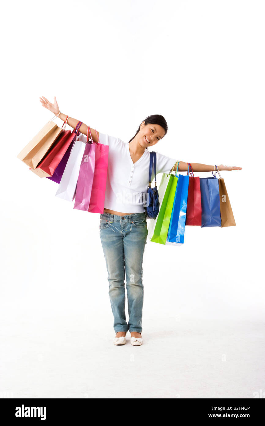Portrait of a young woman carrying shopping bags Stock Photo - Alamy