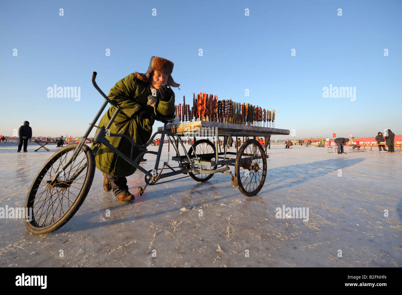 Vendor selling frozen fruit snacks on the frozen Songhua River, Harbin ...