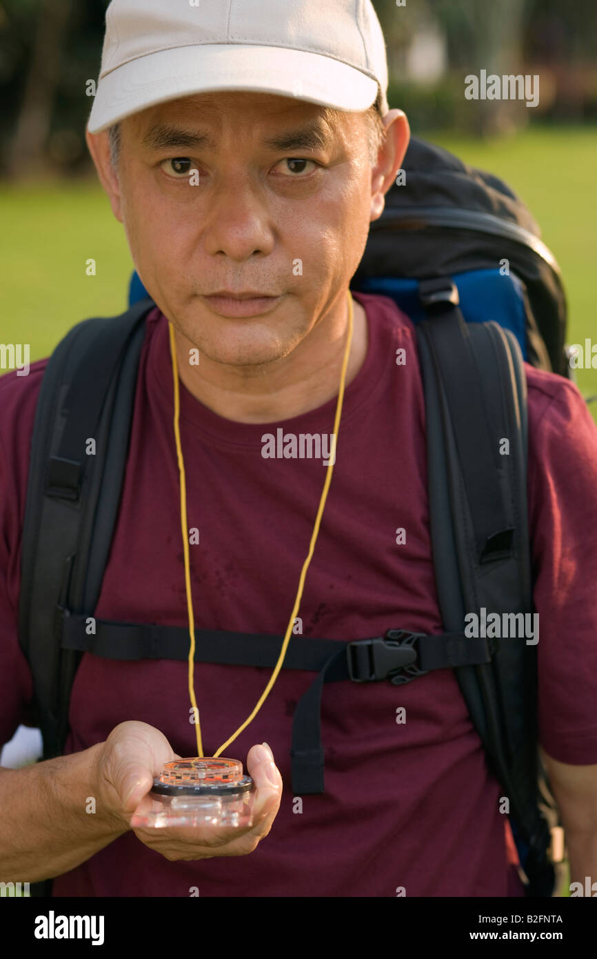 Portrait of a mature man holding a compass Stock Photo - Alamy