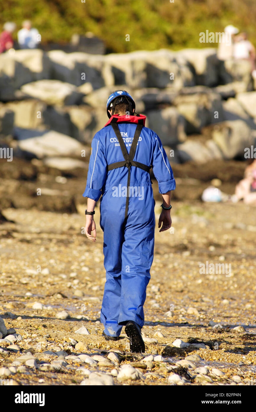 Coastguard on shore rescue volunteer in his blue overalls walking on a ...
