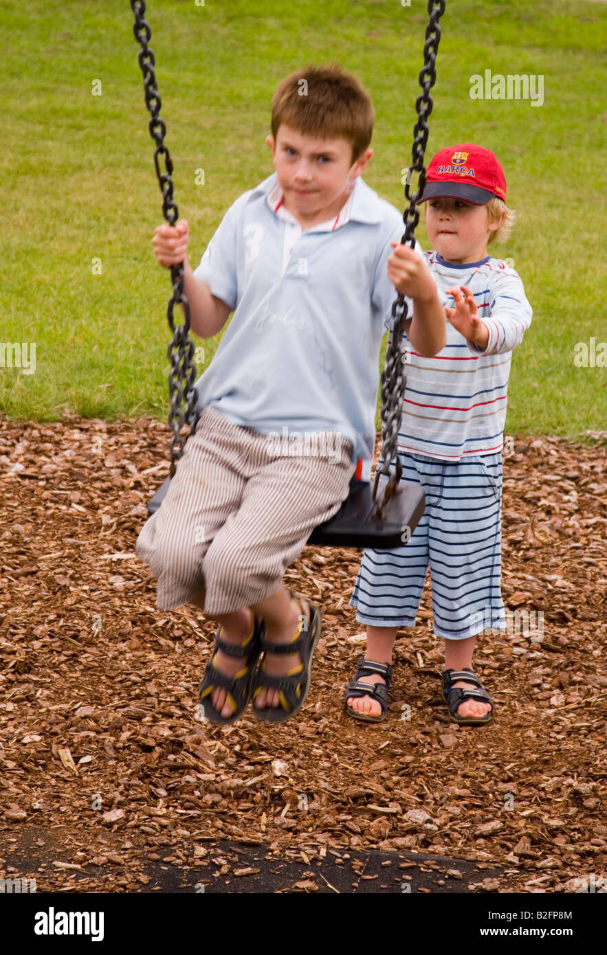 Kids on swing pushing hi-res stock photography and images - Alamy