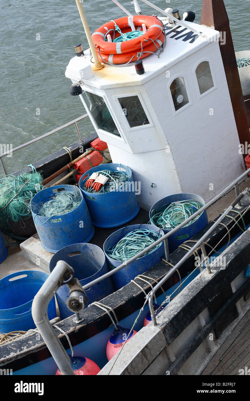 Small fishing boat with nets and lines and cabin in Bridport harbour ...