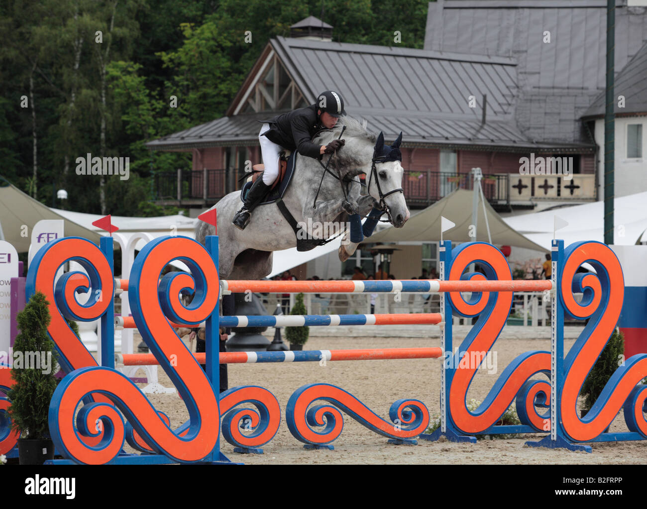 Rider jumping obstacle in showjumping competition Stock Photo - Alamy