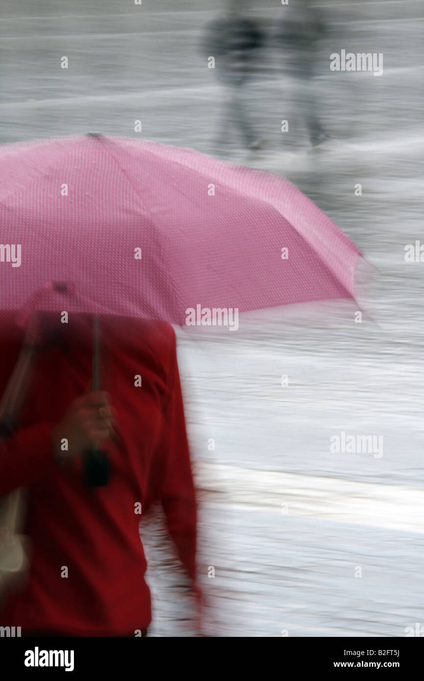 woman with red umbrella in heavy rain in town Stock Photo - Alamy