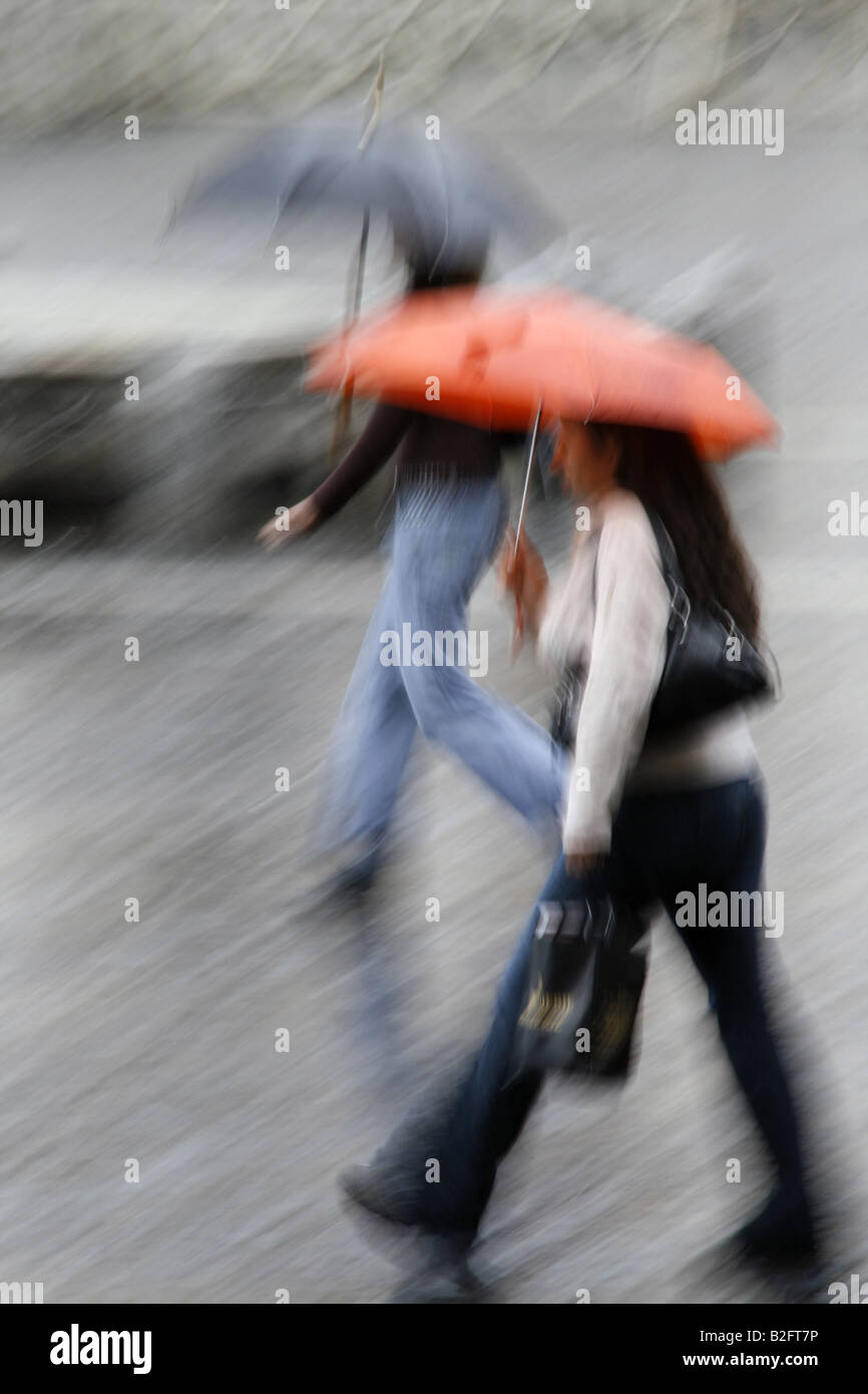 person with umbrella in heavy rain in town Stock Photo - Alamy