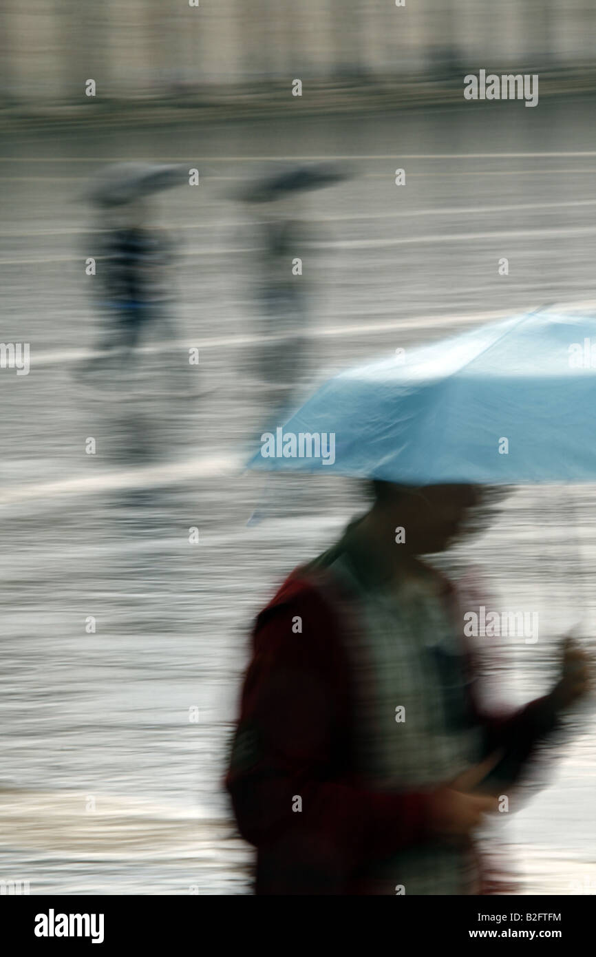 man with umbrella running in heavy rain in town Stock Photo - Alamy