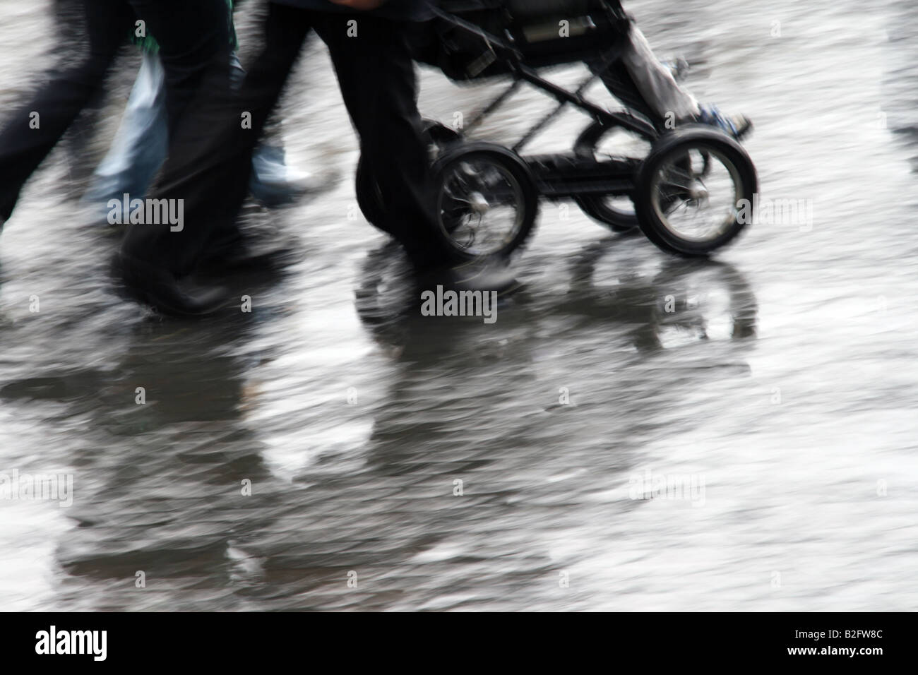 people pushing pram in street in rain in city town Stock Photo - Alamy