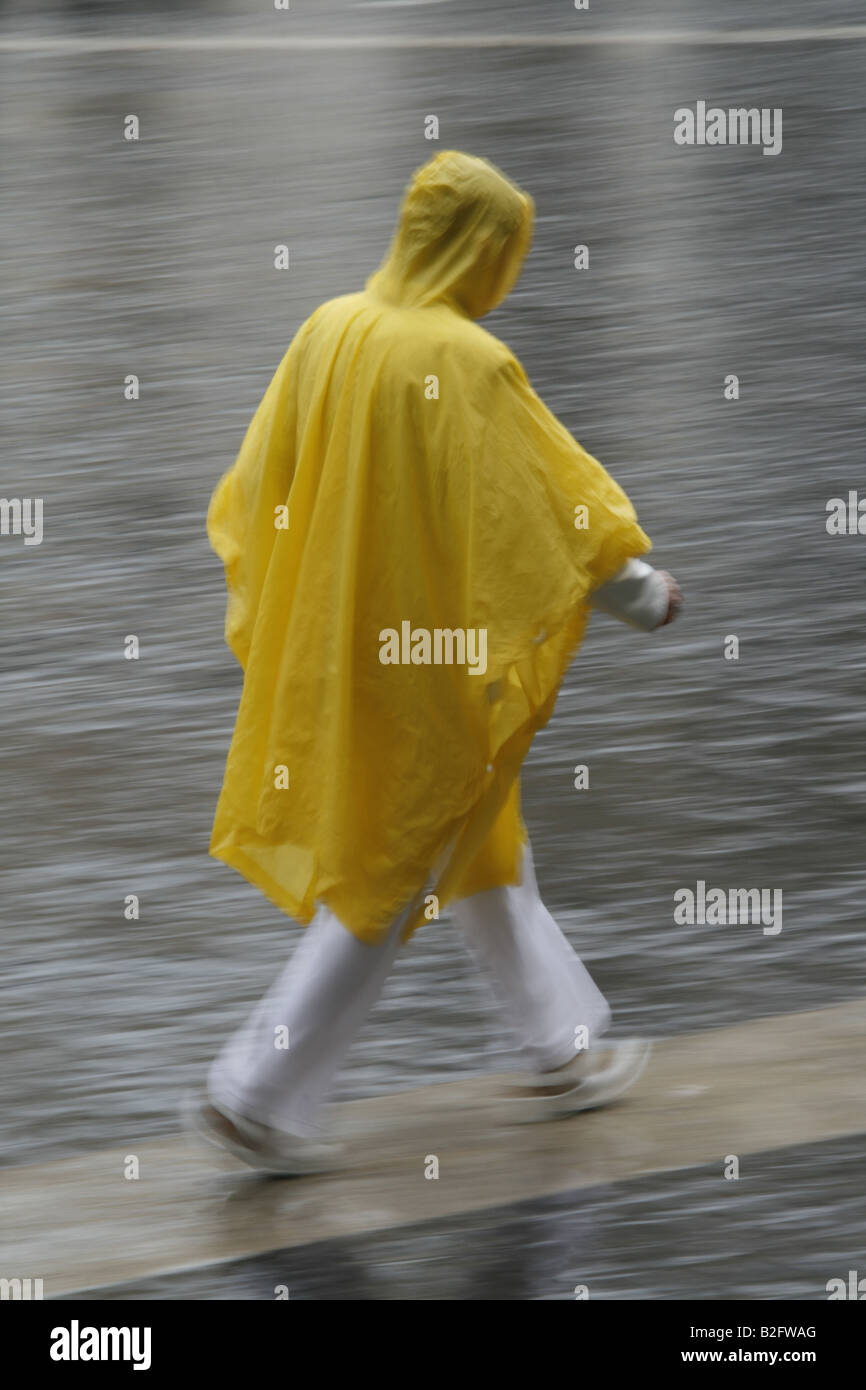 person wearing yellow waterproof coat cape in rain Stock Photo - Alamy