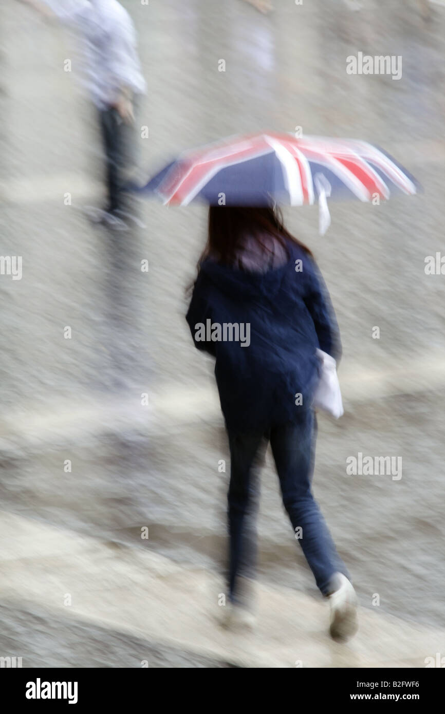 girl with union jack umbrella walking in rain in town Stock Photo - Alamy