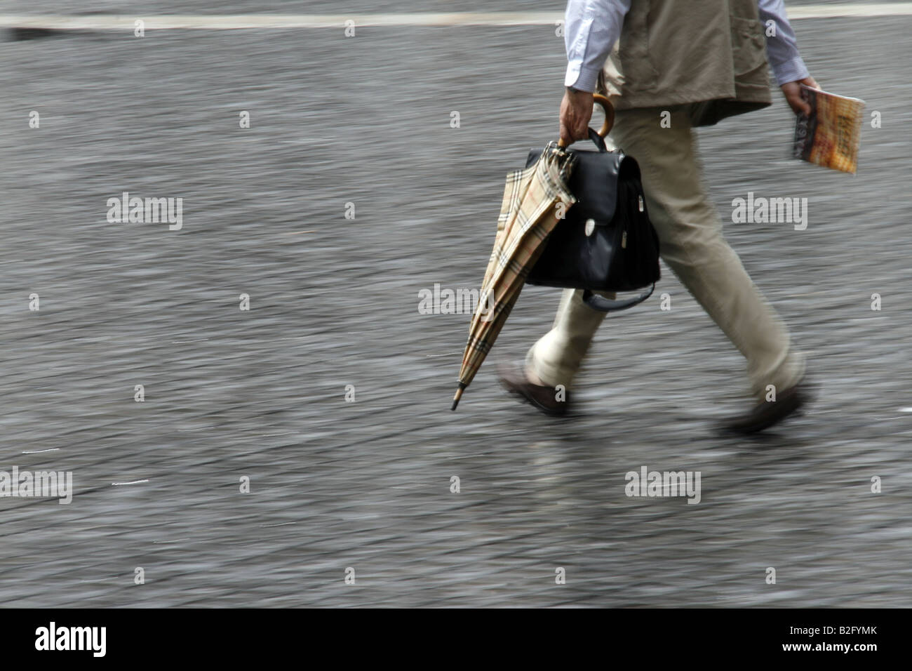 person carrying closed umbrella in town Stock Photo - Alamy
