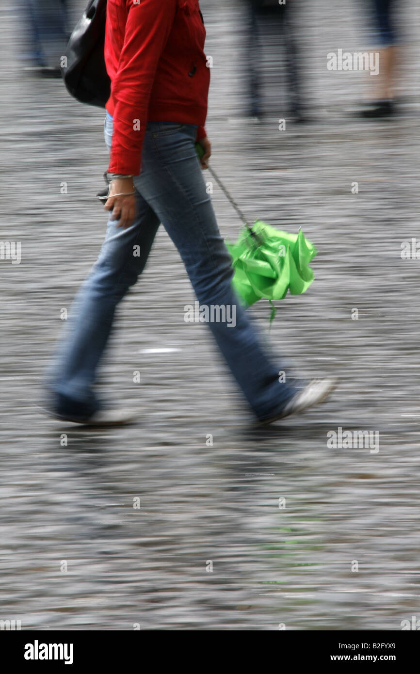 person carrying colourful closed umbrella in town Stock Photo - Alamy