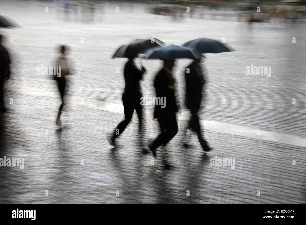 people with umbrellas in heavy rain in town Stock Photo - Alamy
