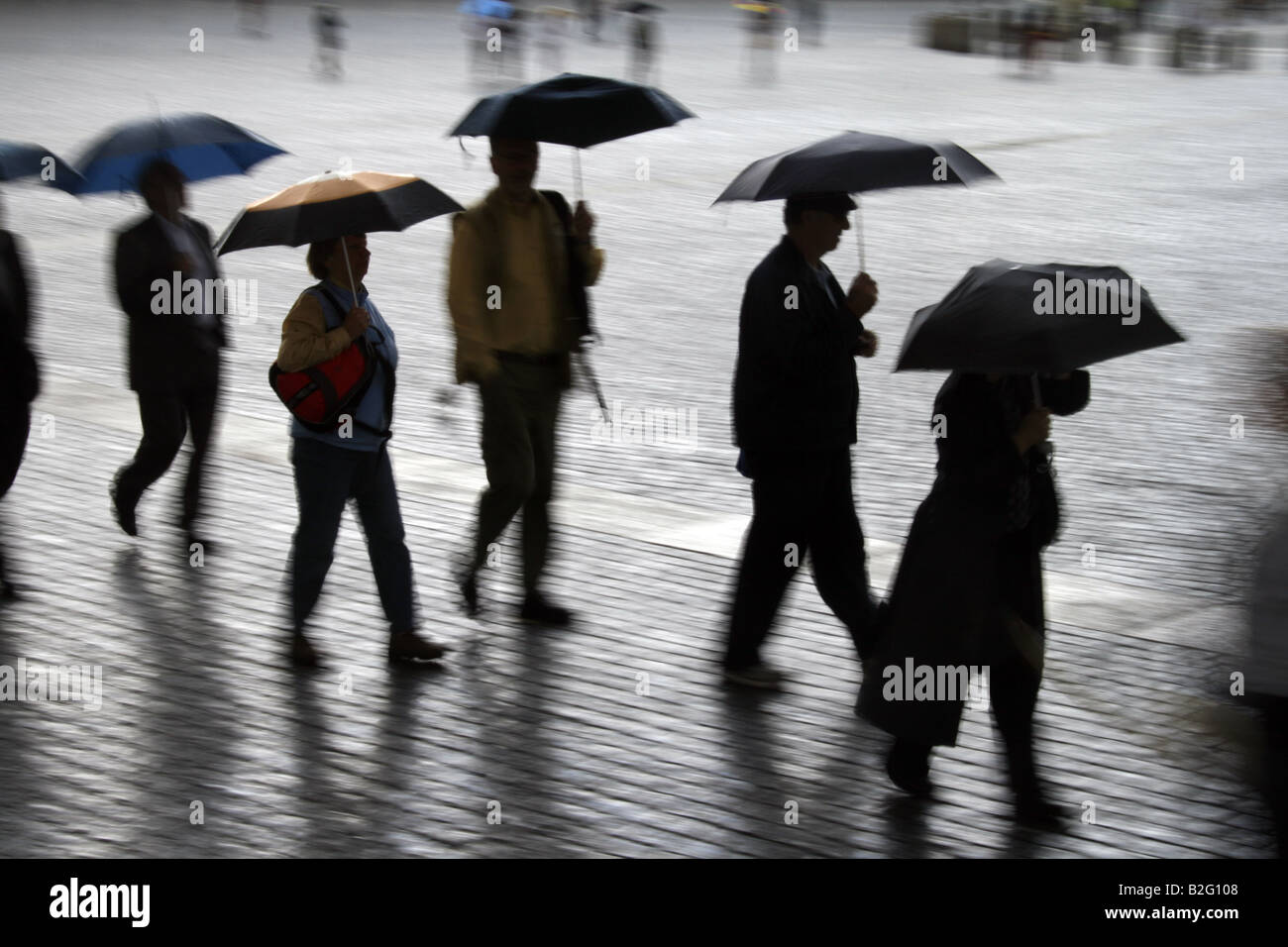 people with umbrellas in heavy rain in town Stock Photo - Alamy