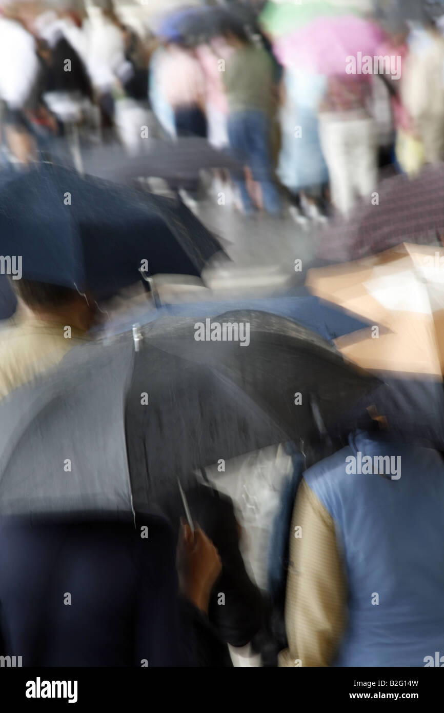 crowd of people with umbrellas in rain in town Stock Photo - Alamy
