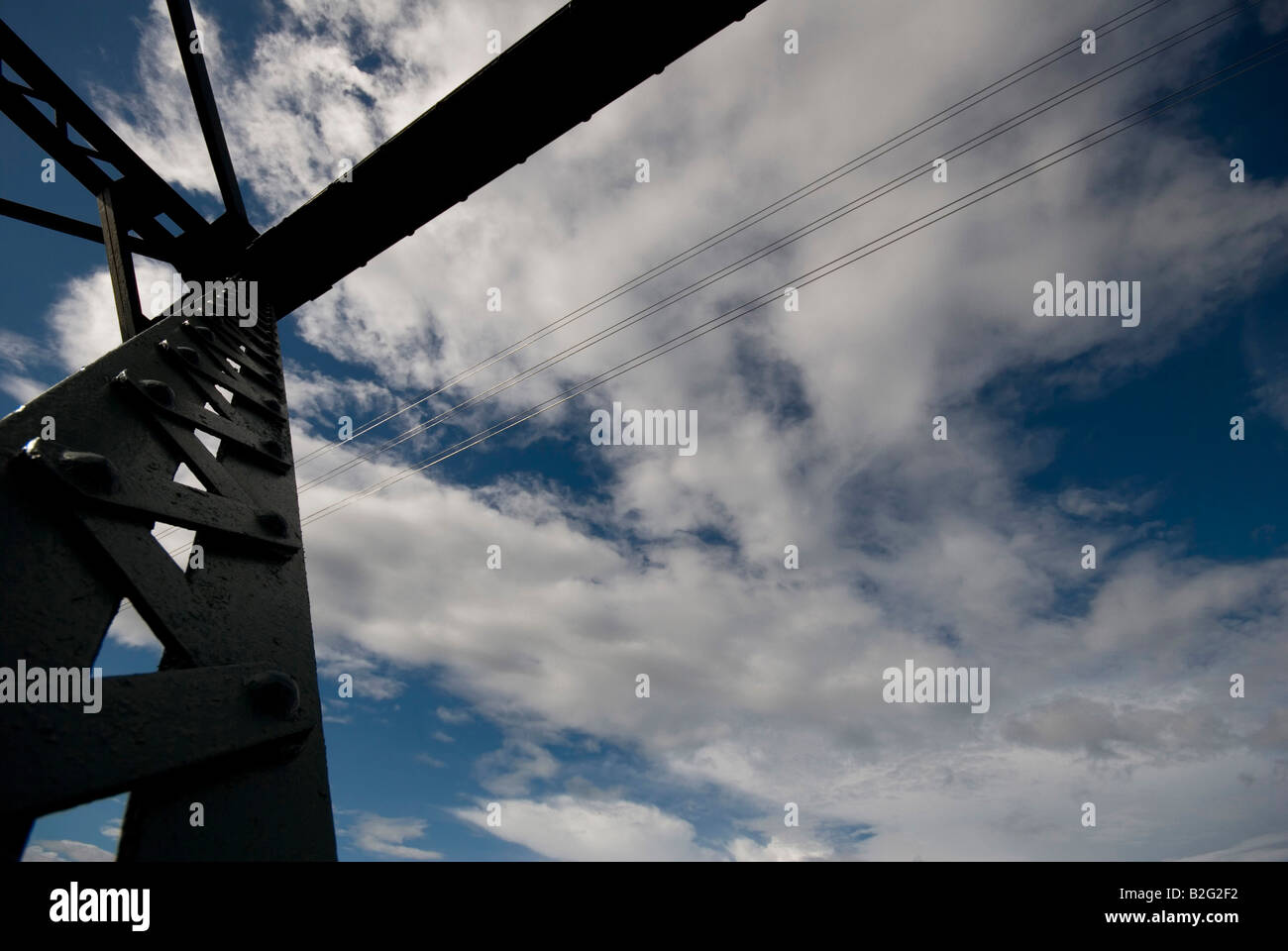 An old steel bridge structure and new electric cables cross in an ...