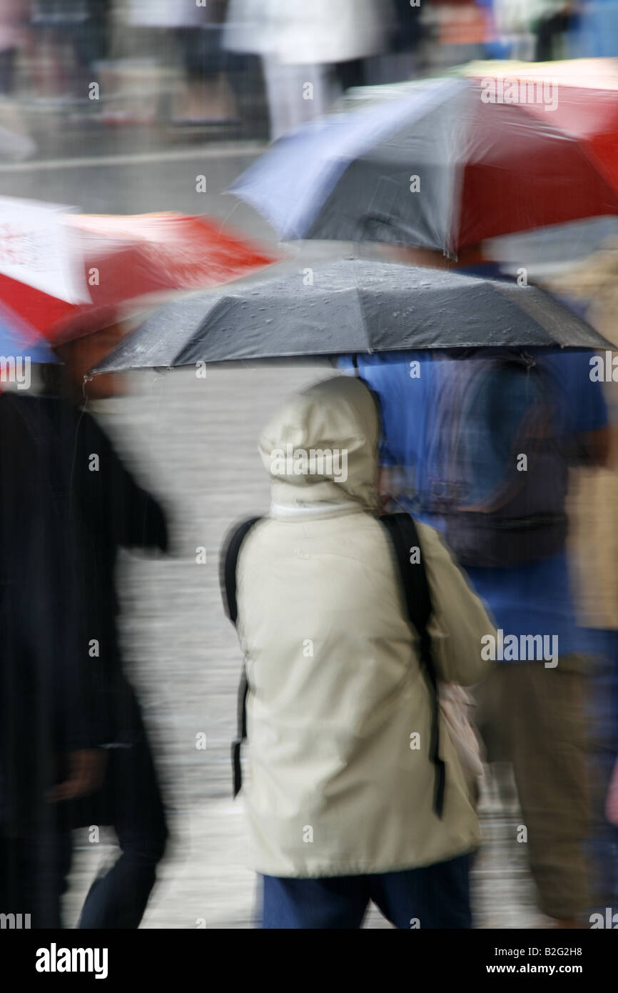 people with umbrellas in heavy rain in town Stock Photo - Alamy