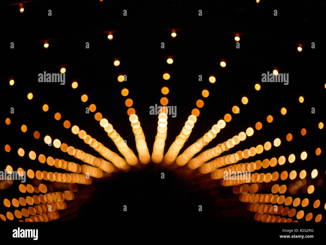 AN ARC OF RECEDING LIGHTS IN THE CEILING OF A HOTEL LOBBY VIEWED FROM ...