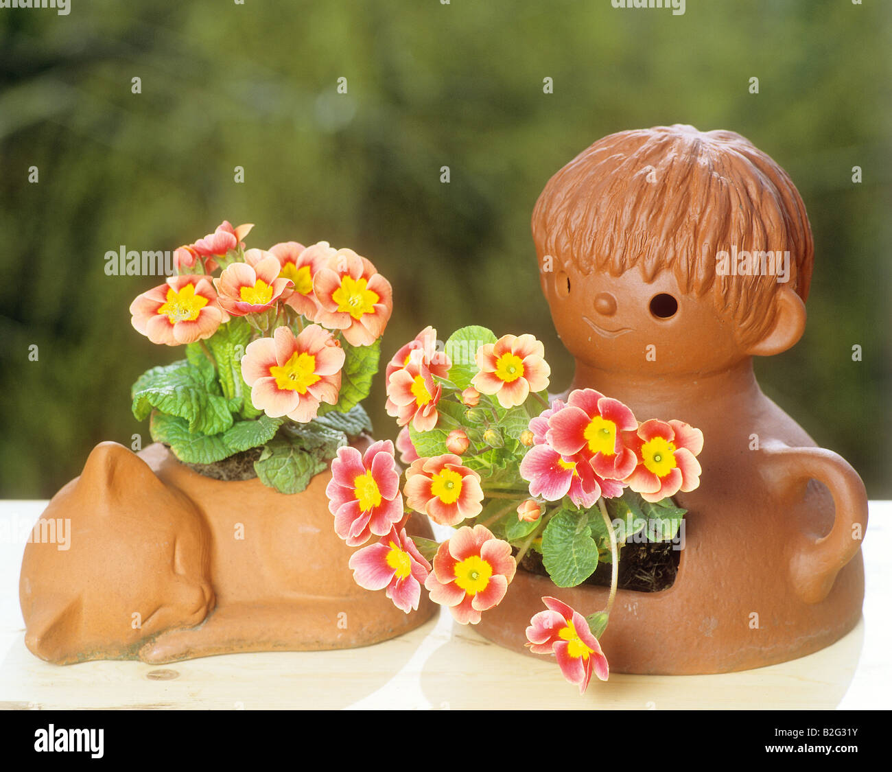 two clay figures with primroses Stock Photo - Alamy