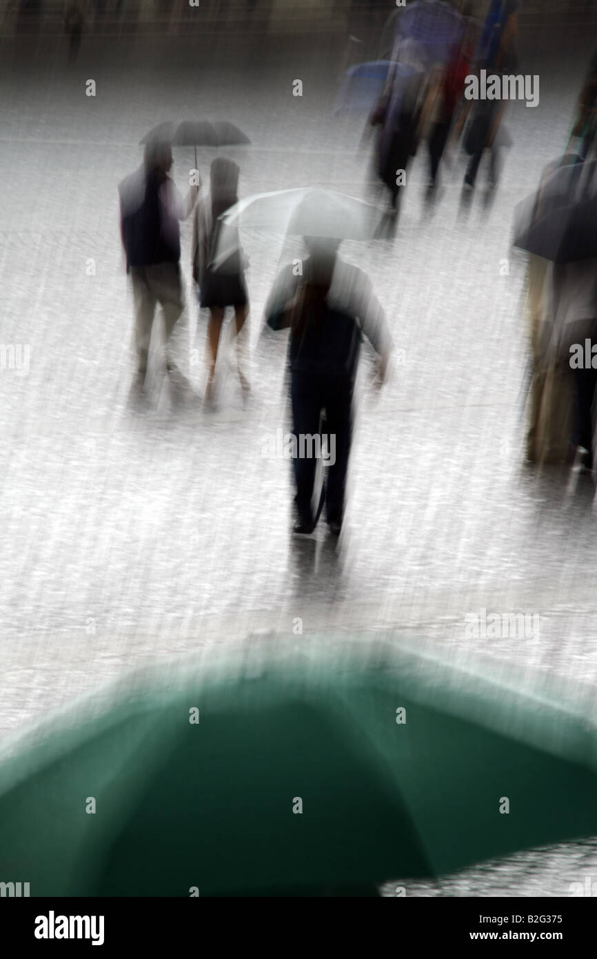 people with umbrellas in heavy rain in town Stock Photo - Alamy