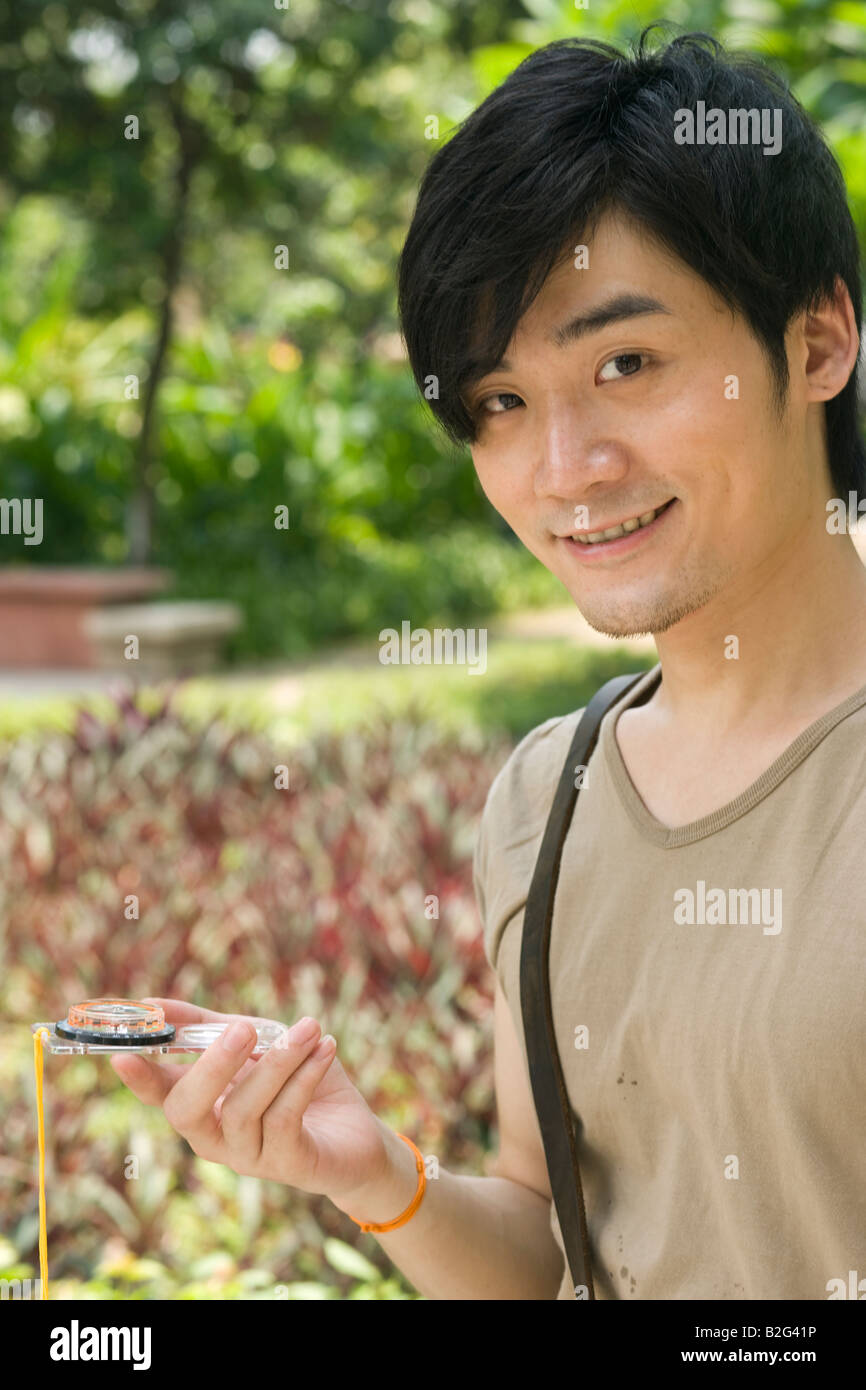 Portrait of a young man holding a compass and smiling Stock Photo - Alamy