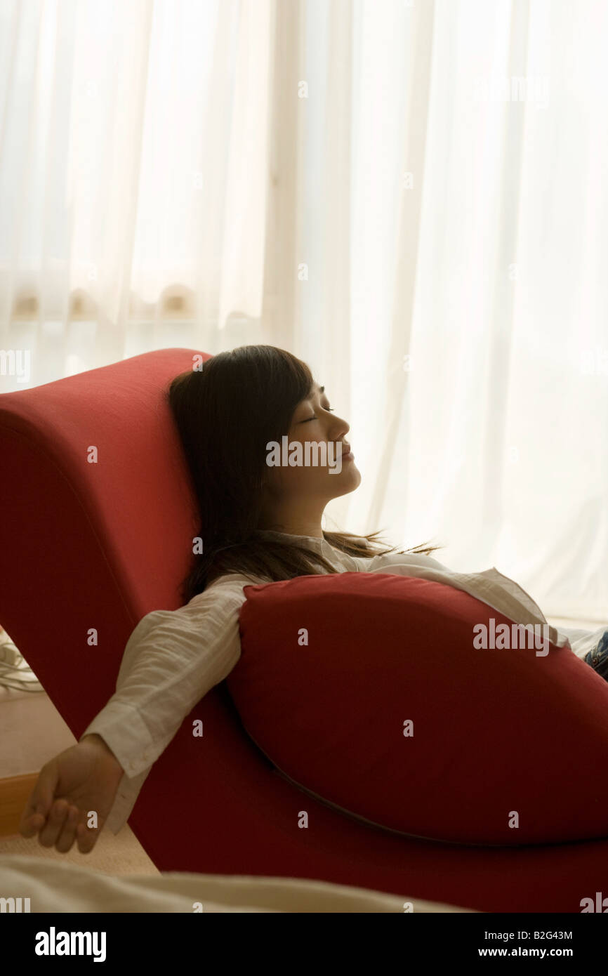 Side profile of a young woman resting on a reclining chair Stock Photo ...