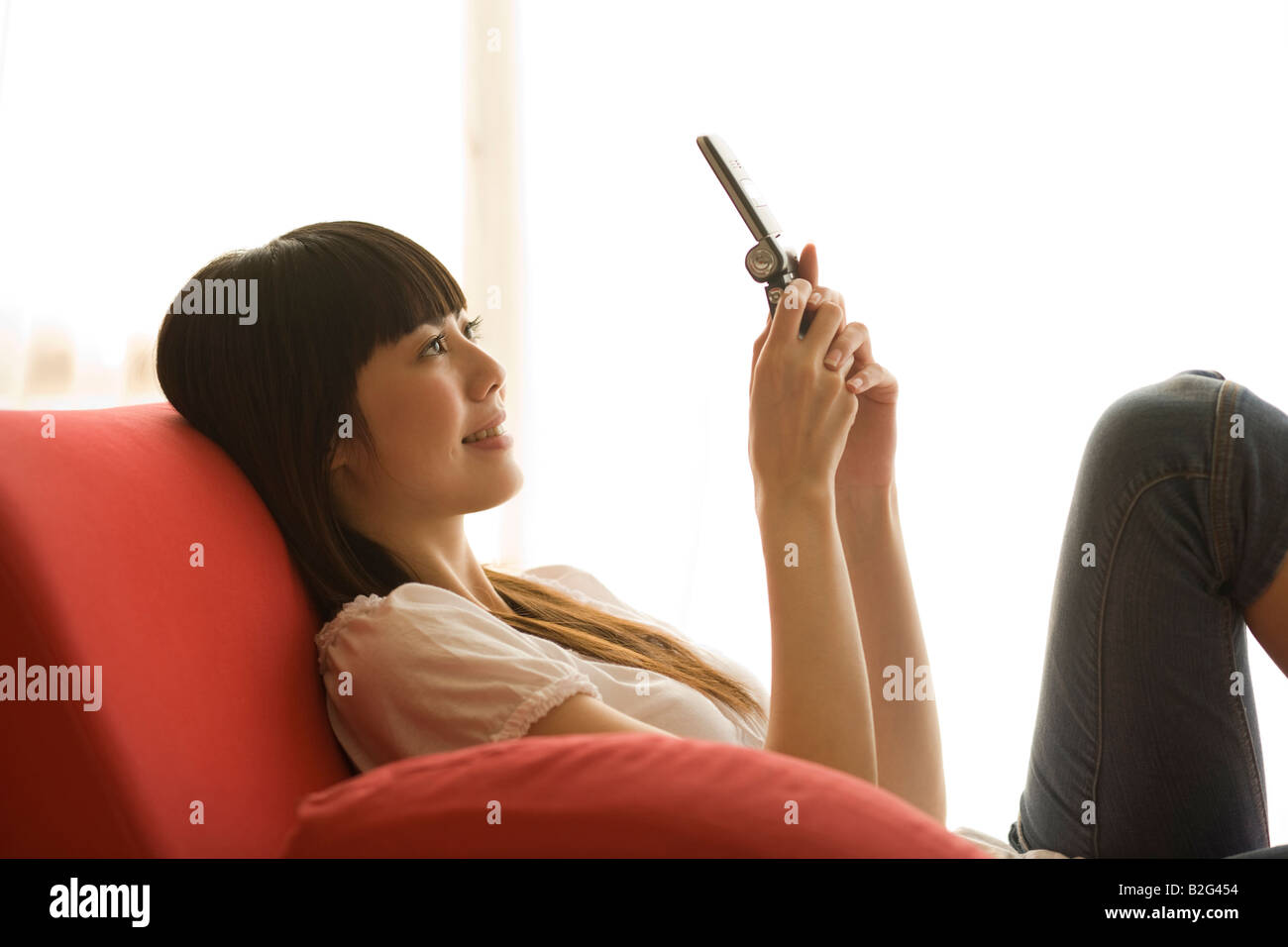 Side profile of a young woman text messaging Stock Photo - Alamy