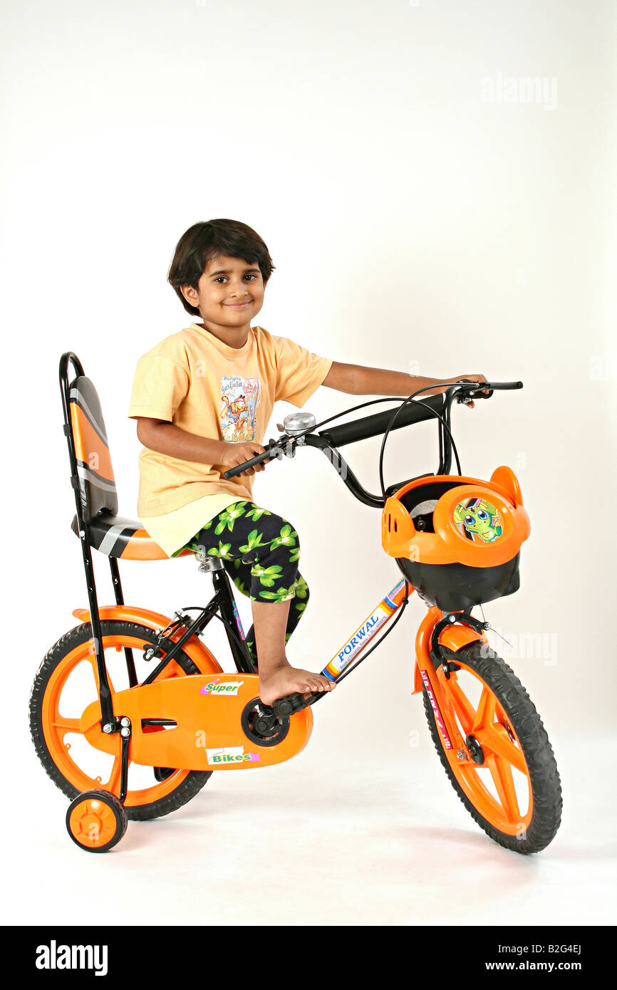 Girl riding bicycle with training wheels Stock Photo - Alamy