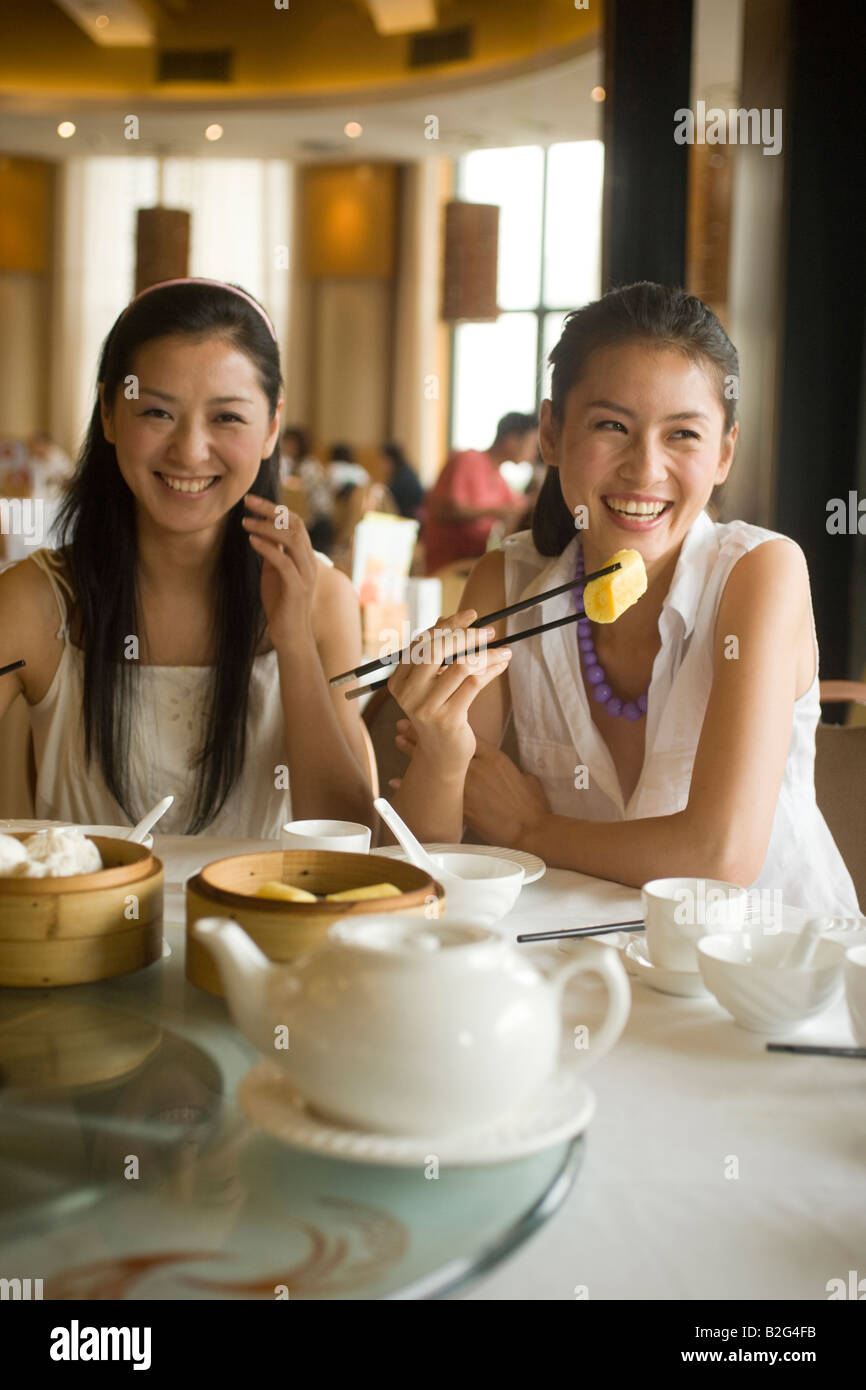 Two young women eating dim sum in a restaurant Stock Photo - Alamy