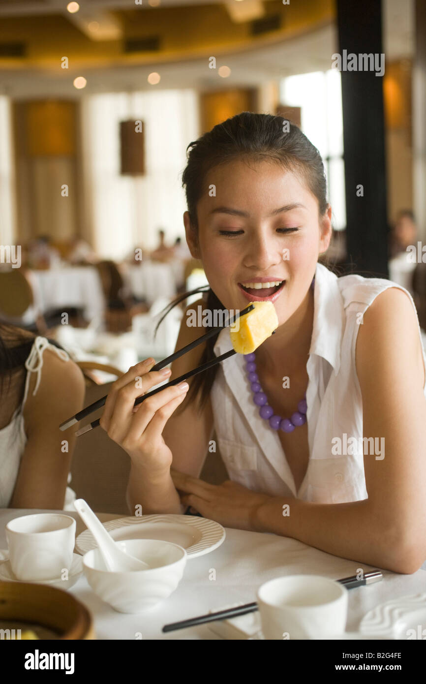 Young woman eating dim sum in a restaurant and smiling Stock Photo - Alamy
