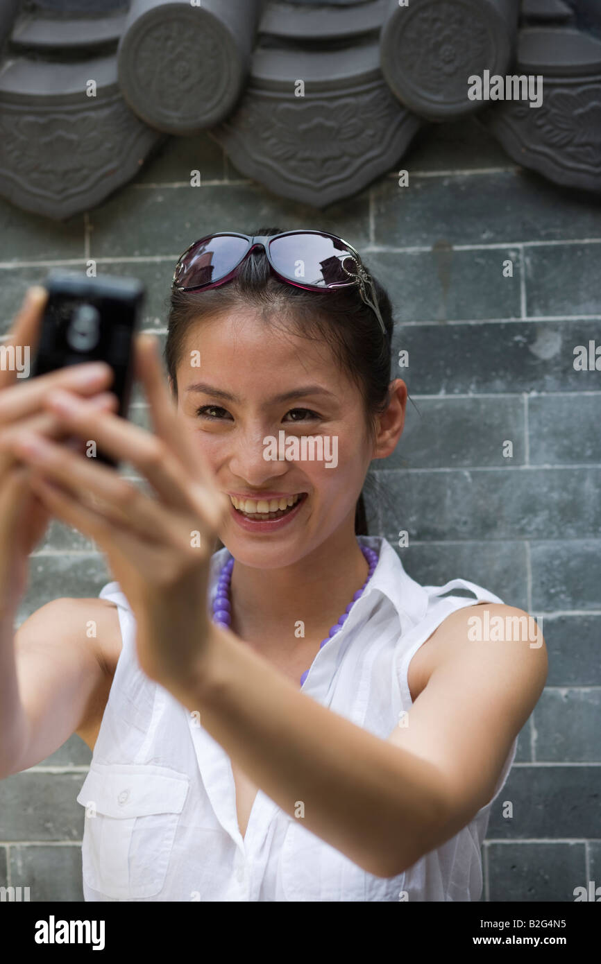 Young woman photographing with a camera phone Stock Photo - Alamy