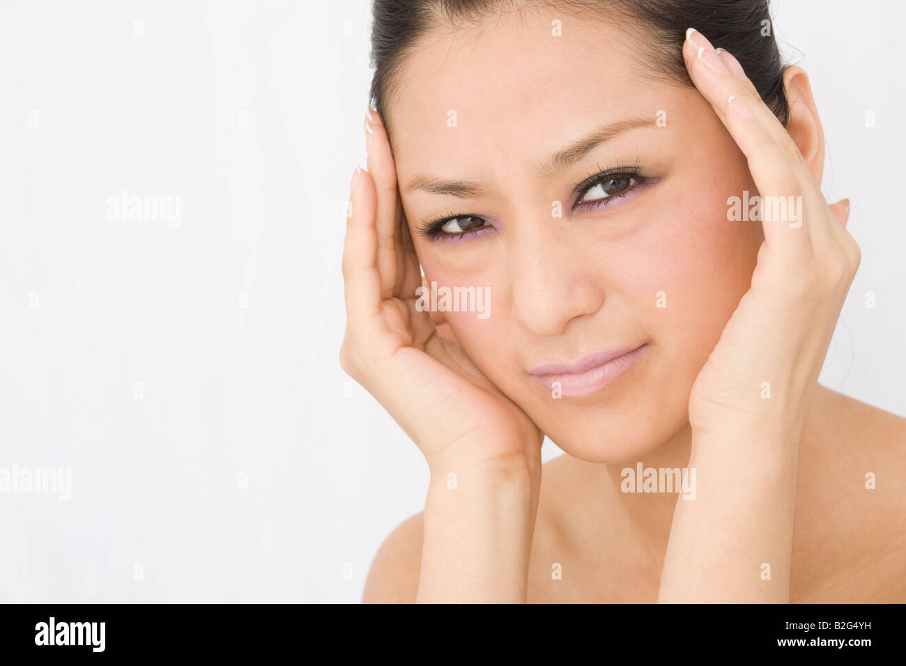 Portrait of a young woman massaging her temples Stock Photo - Alamy