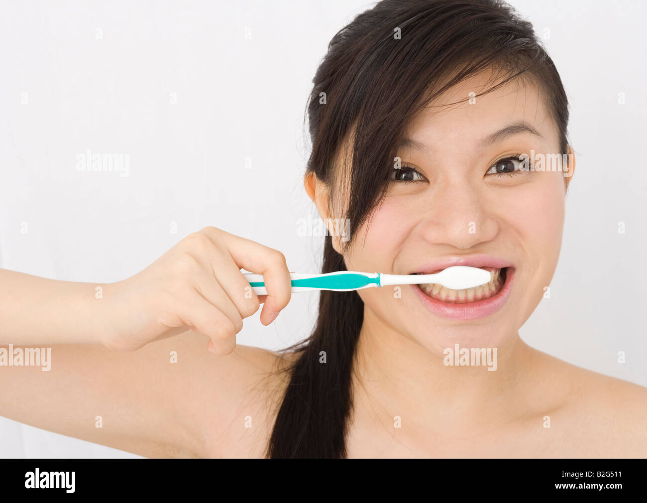 Portrait of a young woman brushing her teeth Stock Photo - Alamy