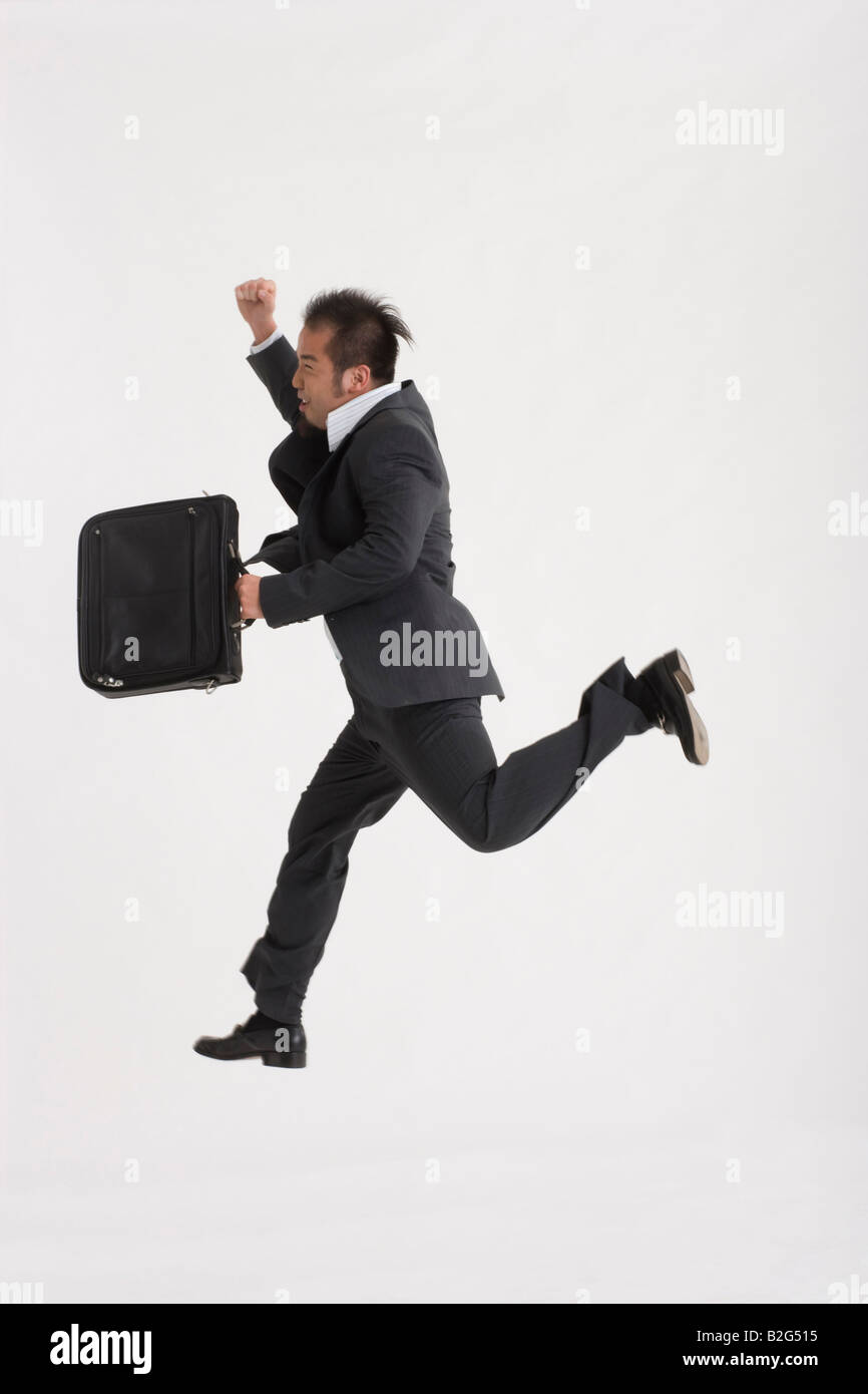 Businessman running with a briefcase Stock Photo - Alamy