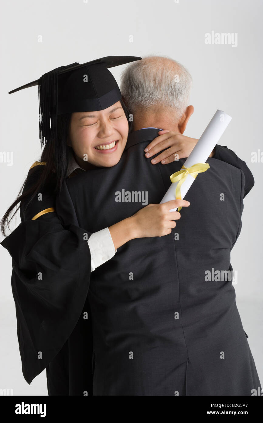 Young female graduate hugging her father and smiling Stock Photo - Alamy
