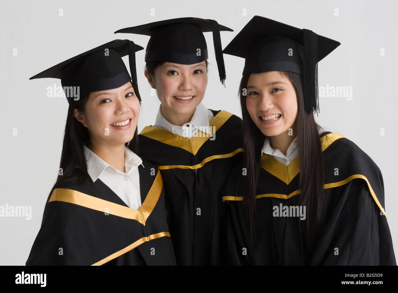 Portrait of three young female graduates smiling together Stock Photo ...