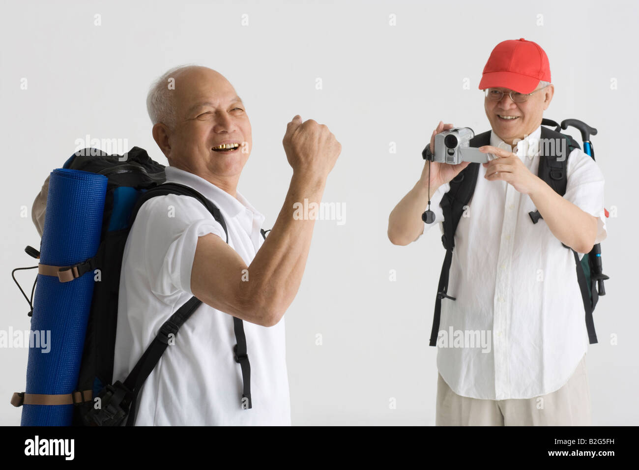 Senior man filming his friend flexing muscles Stock Photo - Alamy