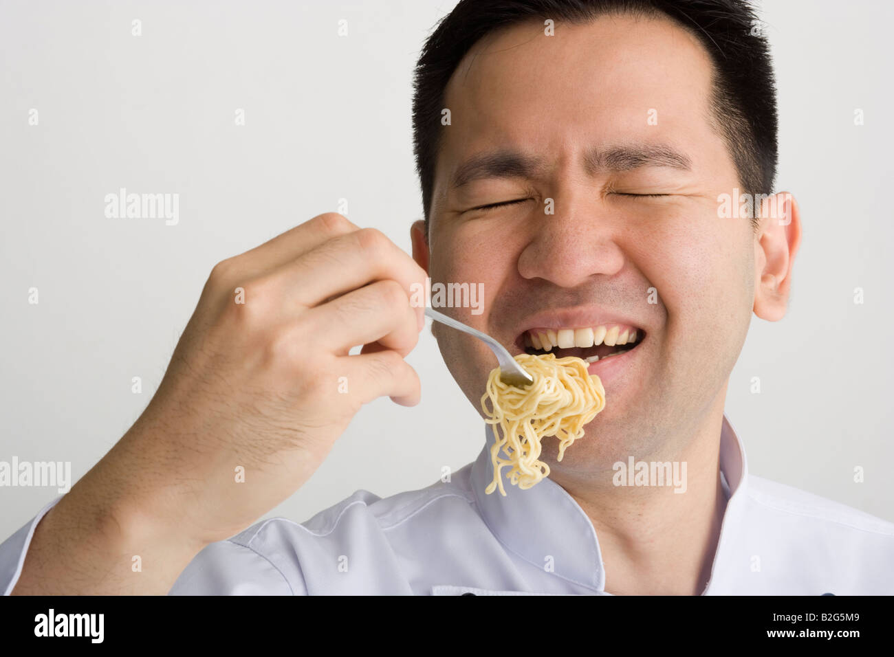 Close-up of a male chef tasting noodles Stock Photo - Alamy